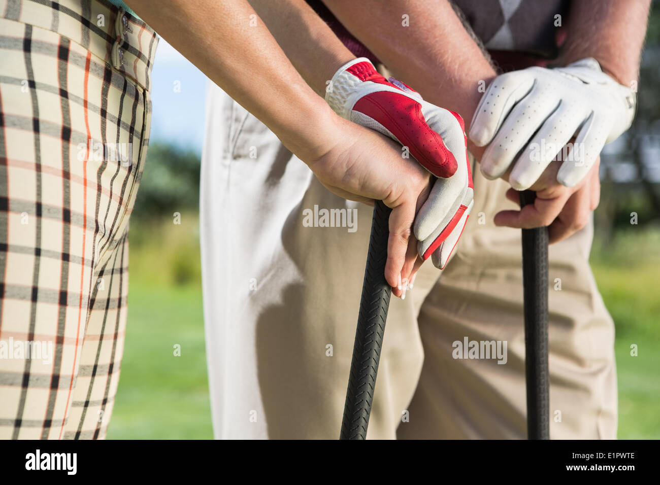 Golfing couple standing holding their clubs Stock Photo - Alamy