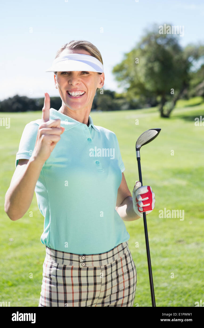 Female golfer standing and pointing up Stock Photo - Alamy