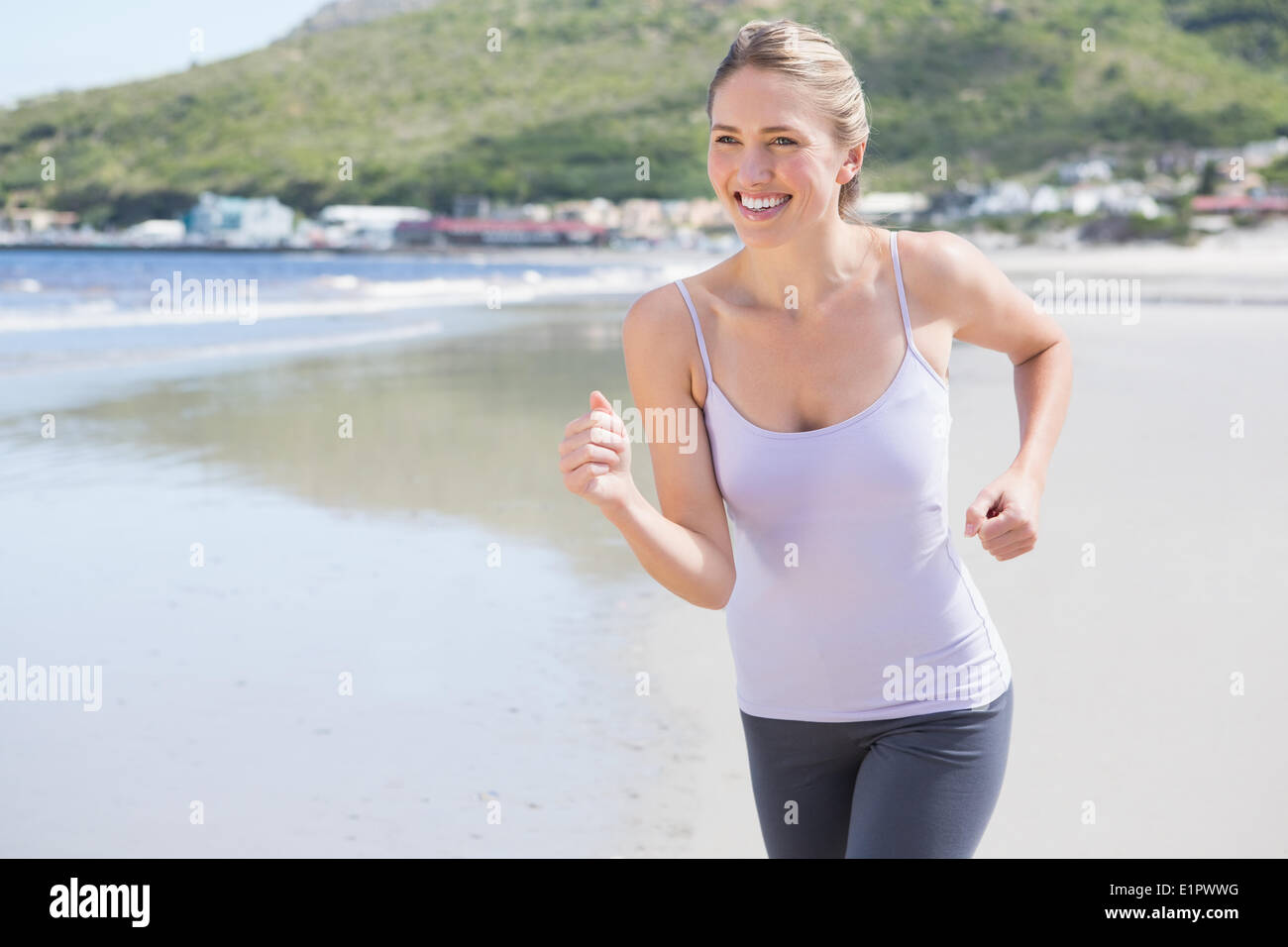 Pretty blonde jogging on the beach Stock Photo - Alamy