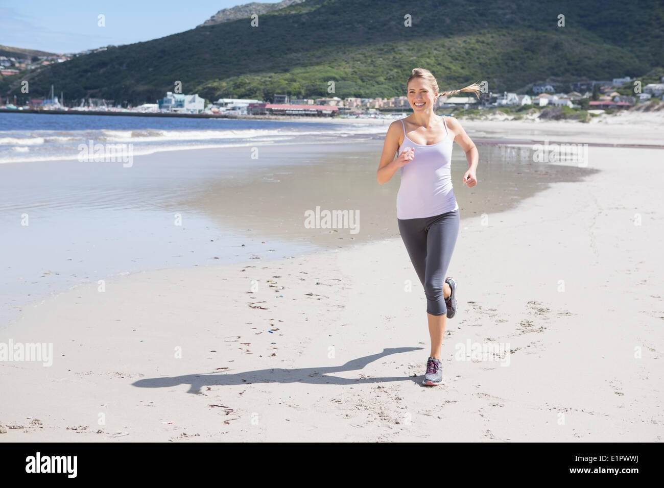 Pretty blonde jogging on the beach Stock Photo - Alamy