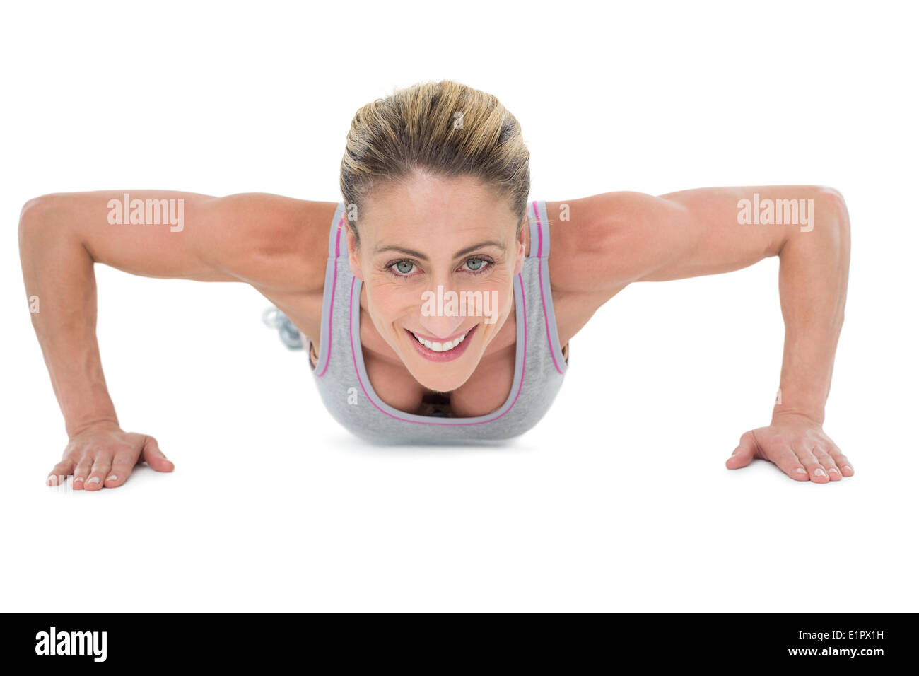 Strong woman doing press ups smiling at camera Stock Photo - Alamy