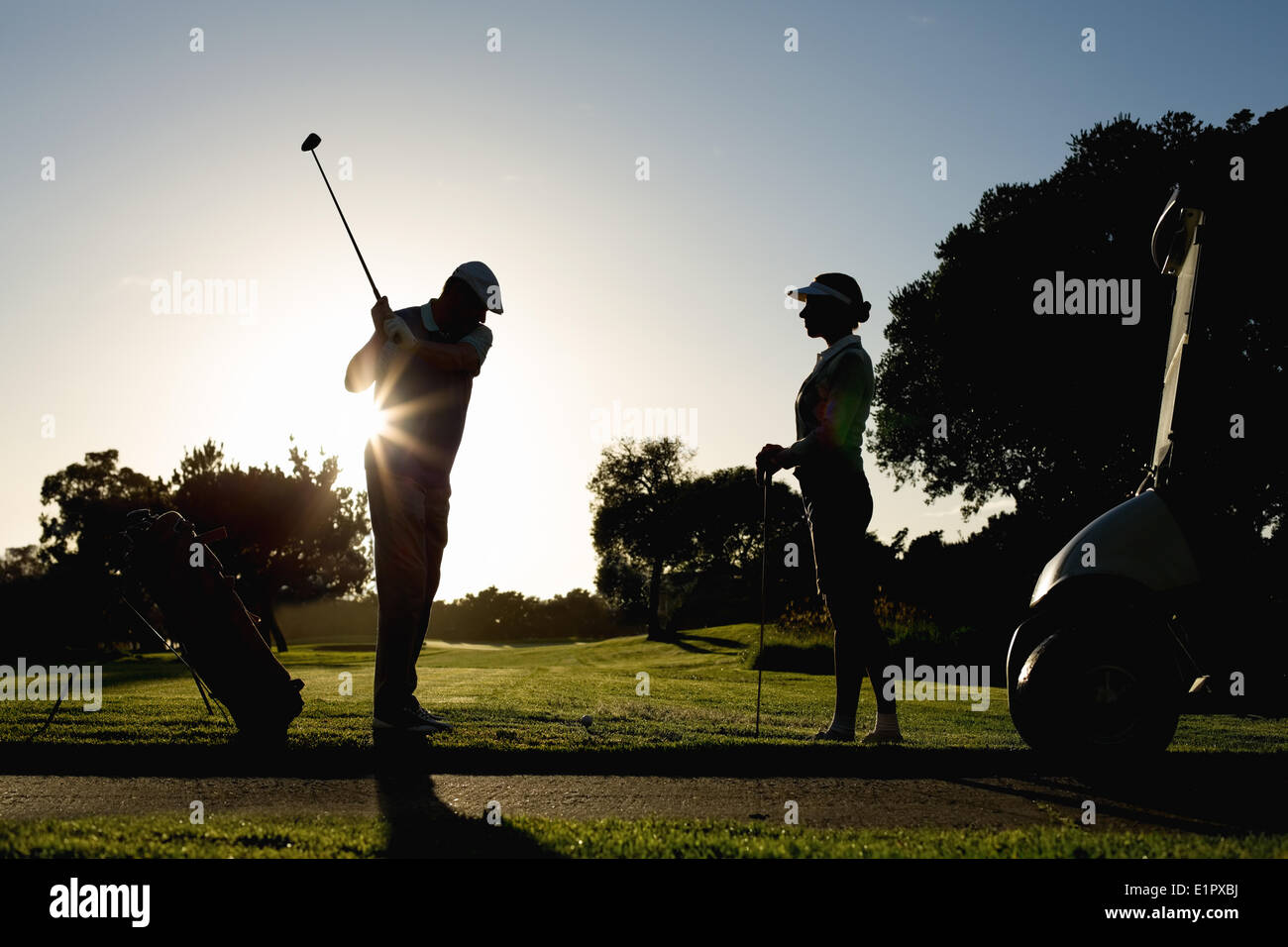 Golfing couple teeing off for the day Stock Photo - Alamy