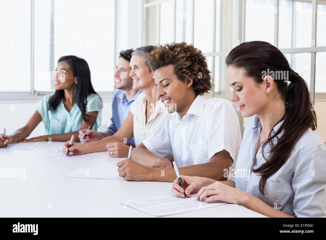 Casual business team taking notes in meeting Stock Photo - Alamy