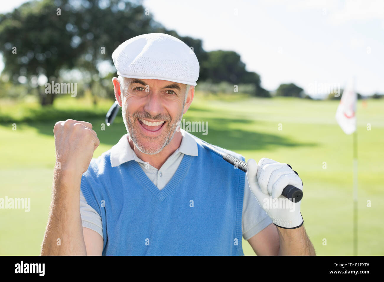 Happy golfer cheering at camera on putting green Stock Photo - Alamy