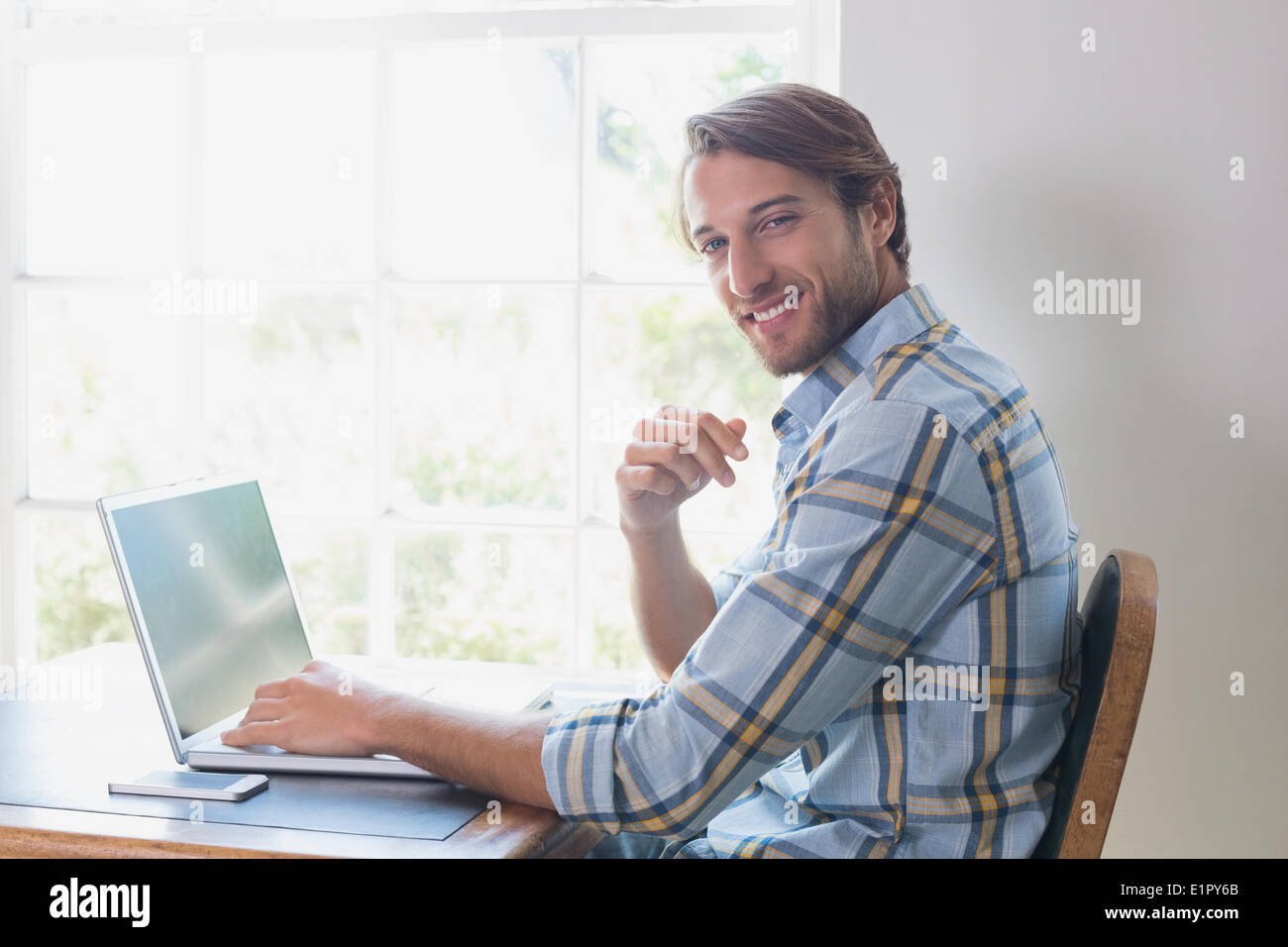 Smiling man sitting table using hi-res stock photography and images - Alamy
