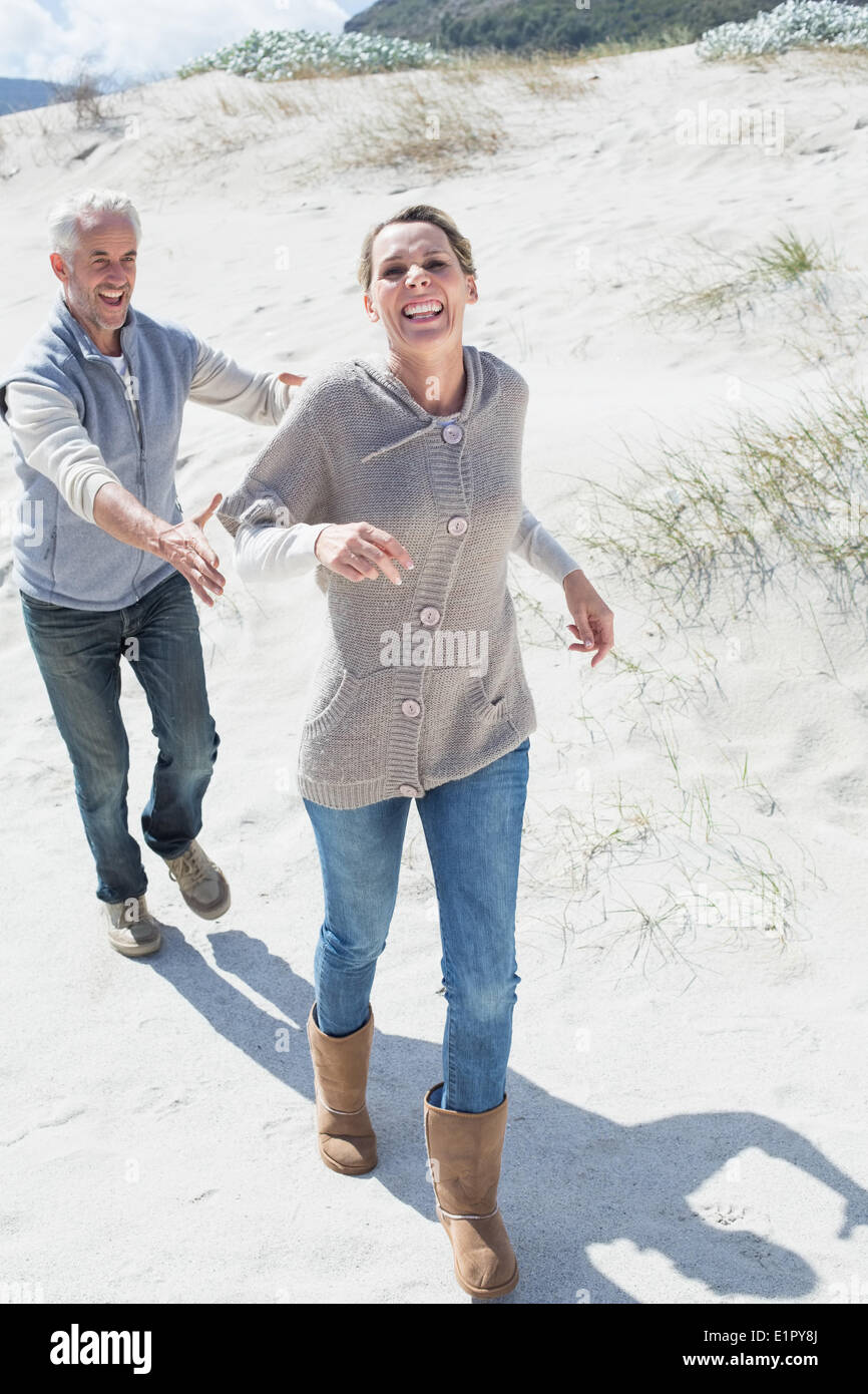 Attractive couple playing chasing on the beach Stock Photo - Alamy