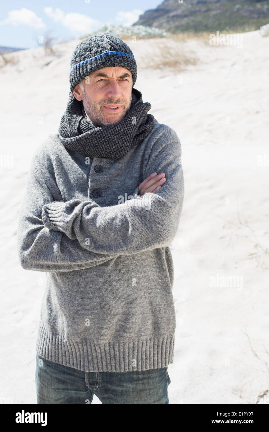 Attractive man shivering on the beach in hat and scarf Stock Photo - Alamy