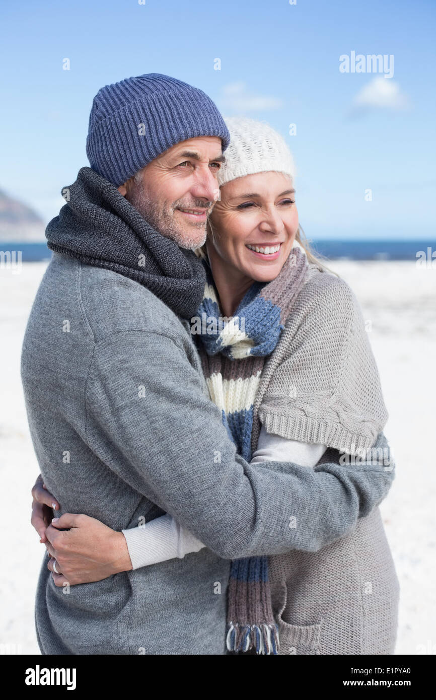 Attractive couple hugging on the beach in warm clothing Stock Photo - Alamy