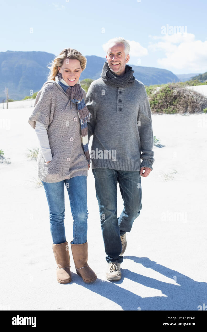 Smiling couple strolling on the beach in warm clothing Stock Photo - Alamy