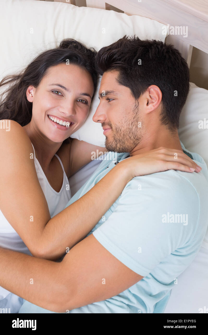 Attractive couple cuddling on bed Stock Photo - Alamy