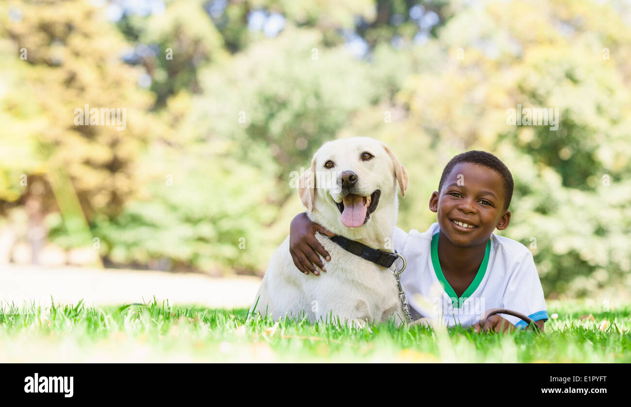 Cute little boy lying with labrador dog Stock Photo - Alamy