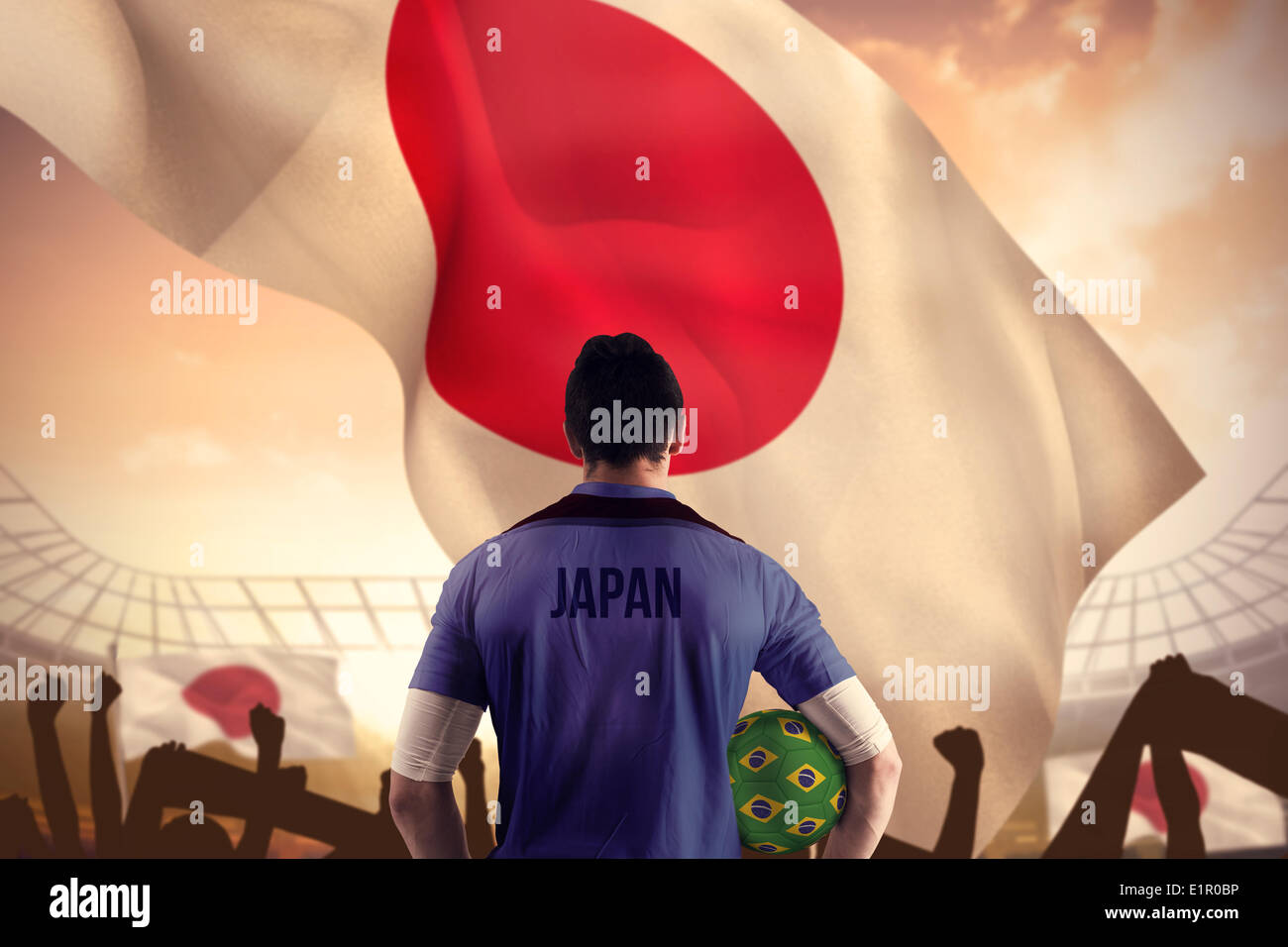 Composite image of japan football player holding ball Stock Photo - Alamy