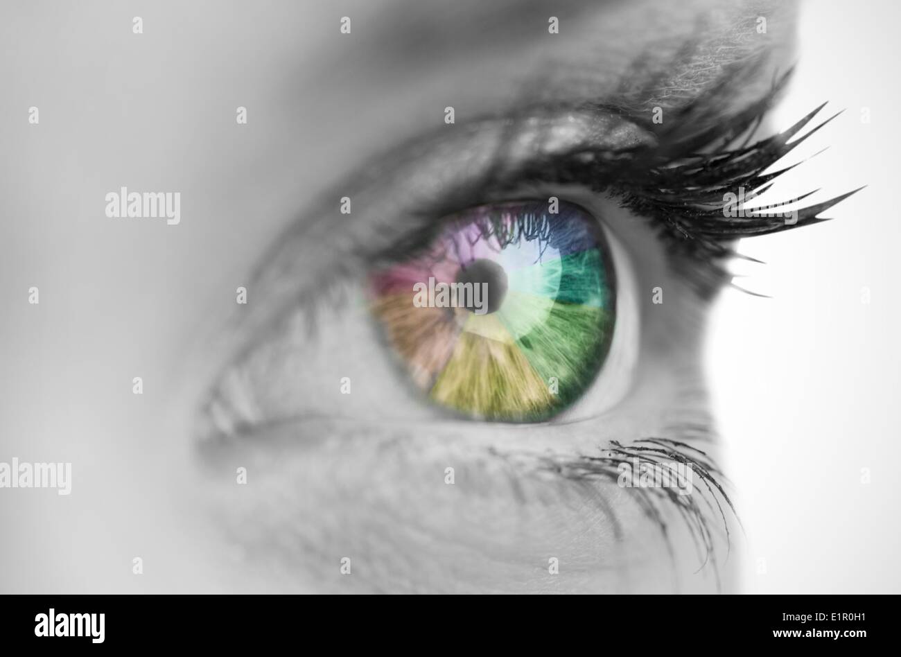 Multi colored eye on grey face Stock Photo - Alamy