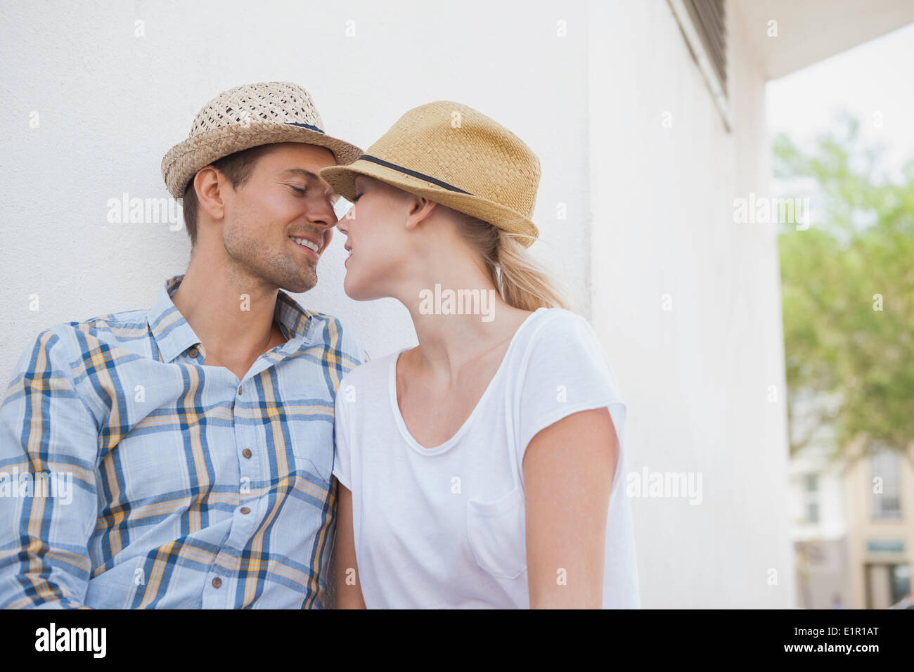 Young hip couple sitting on bench about to kiss Stock Photo - Alamy