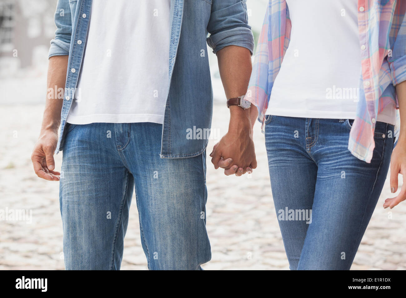 Hip young couple holding hands Stock Photo - Alamy