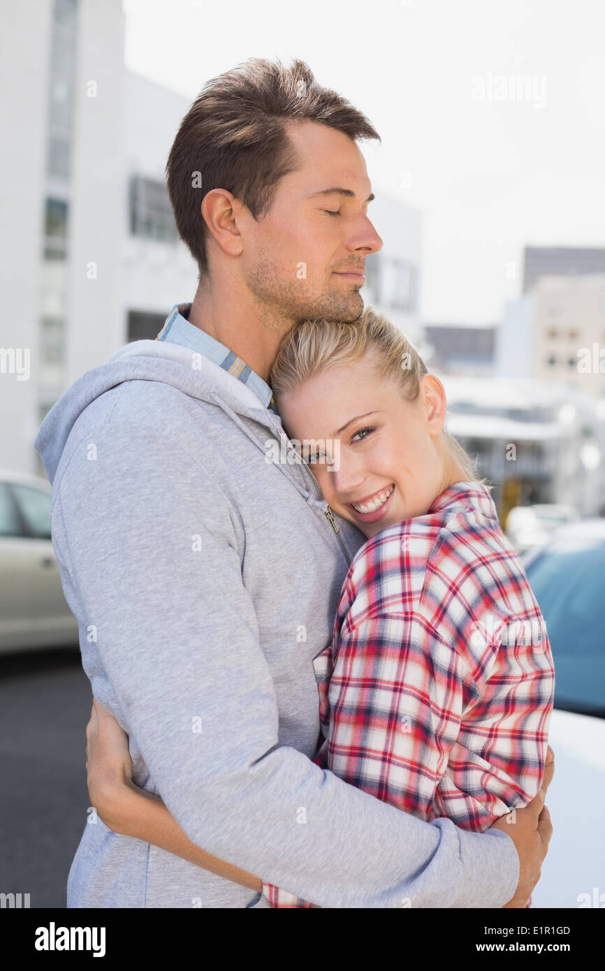 Hip young couple hugging woman smiling at camera Stock Photo - Alamy