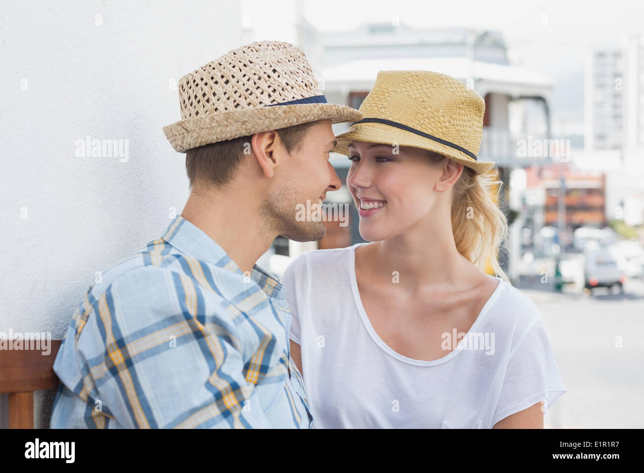 Young hip couple sitting on bench about to kiss Stock Photo - Alamy