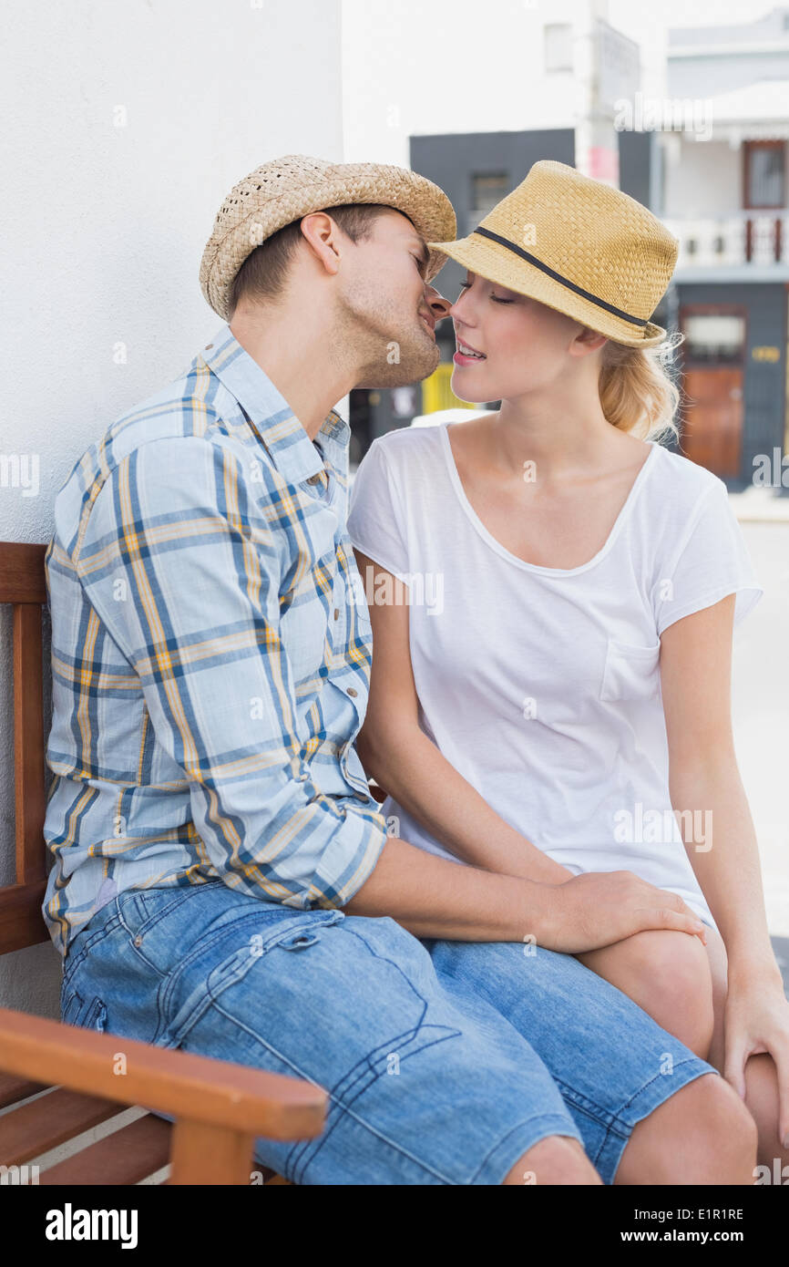 Young hip couple sitting on bench about to kiss Stock Photo - Alamy