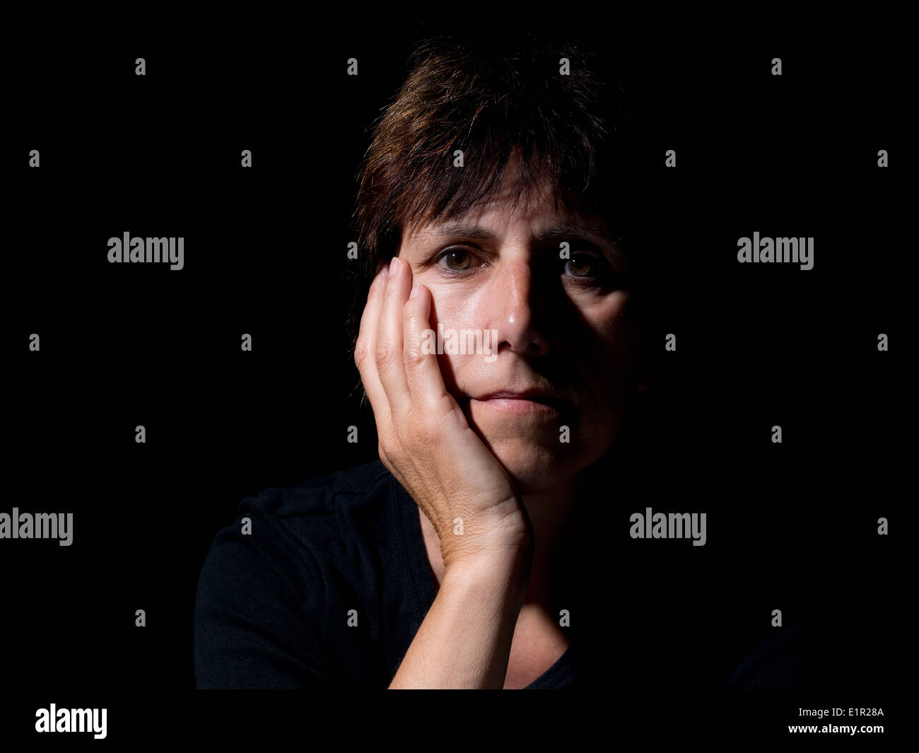 Shady lady. Middle aged woman with strong Rembrandt style lighting ...