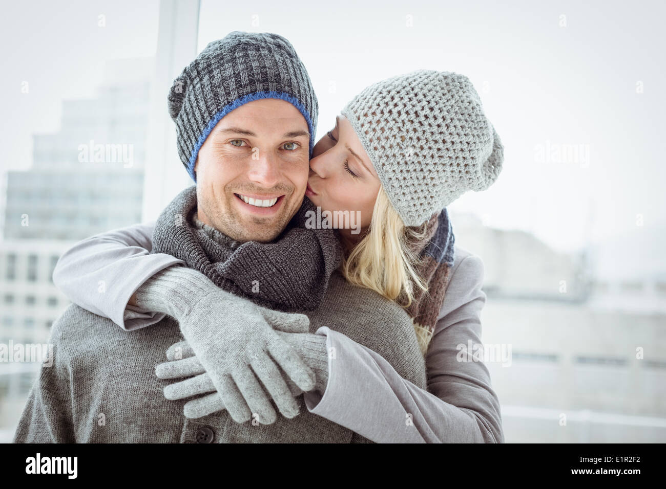 Cute couple in warm clothing hugging man smiling at camera Stock Photo ...