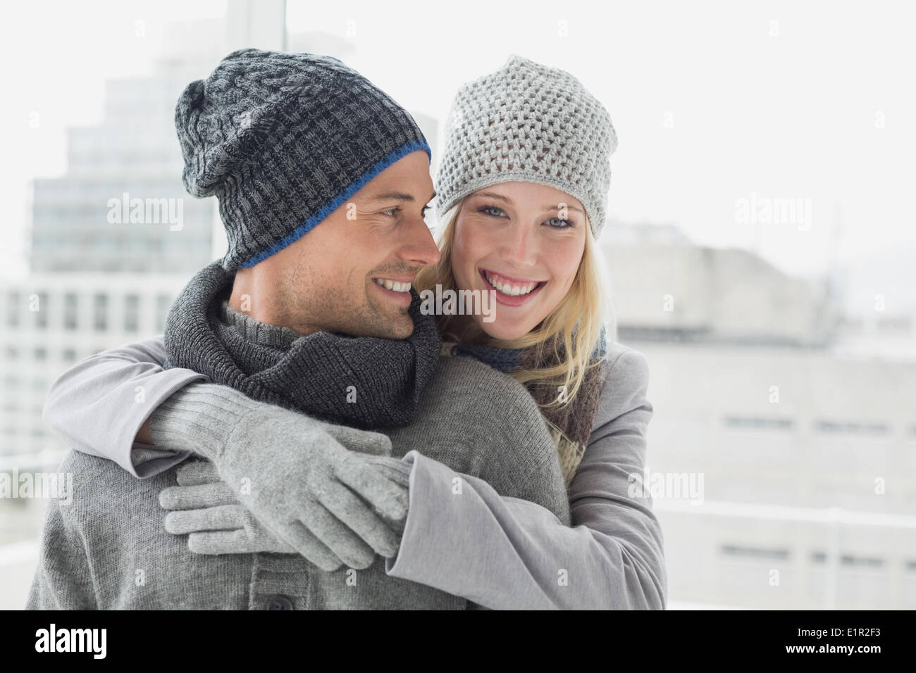 Cute couple in warm clothing hugging woman smiling at camera Stock ...