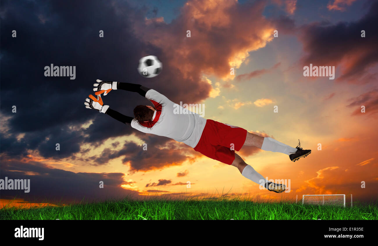 Composite image of goalkeeper in white jumping up Stock Photo - Alamy