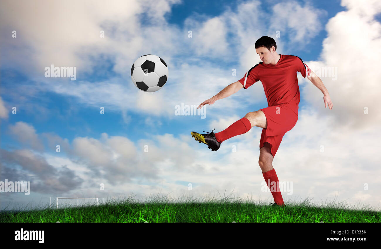 Composite image of football player in red kicking Stock Photo - Alamy