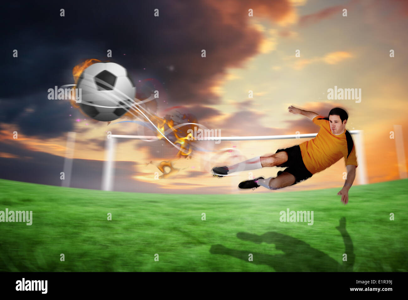 Composite image of football player in orange kicking Stock Photo - Alamy