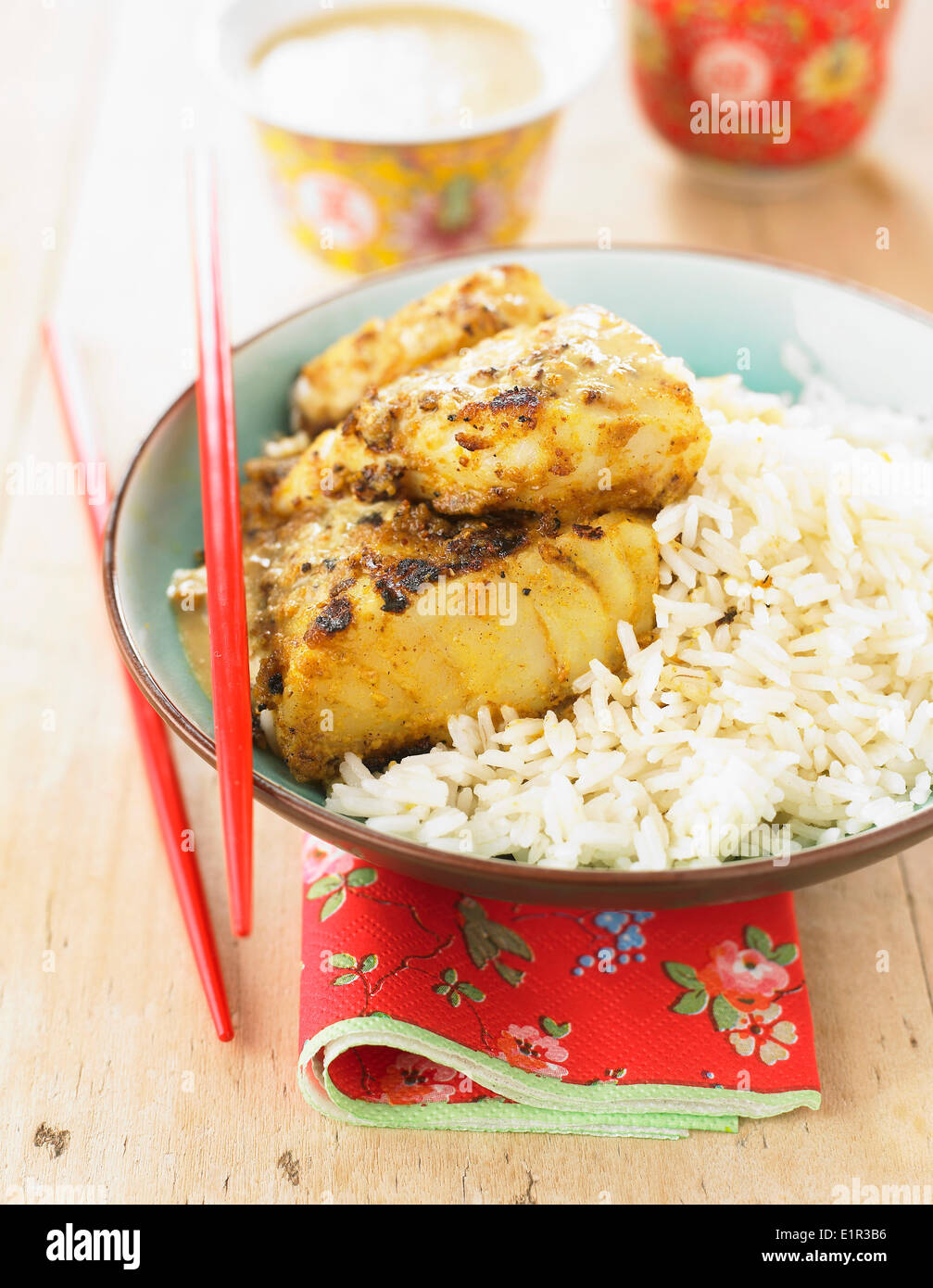 Thick pieces of cod with curry paste and rice Stock Photo - Alamy