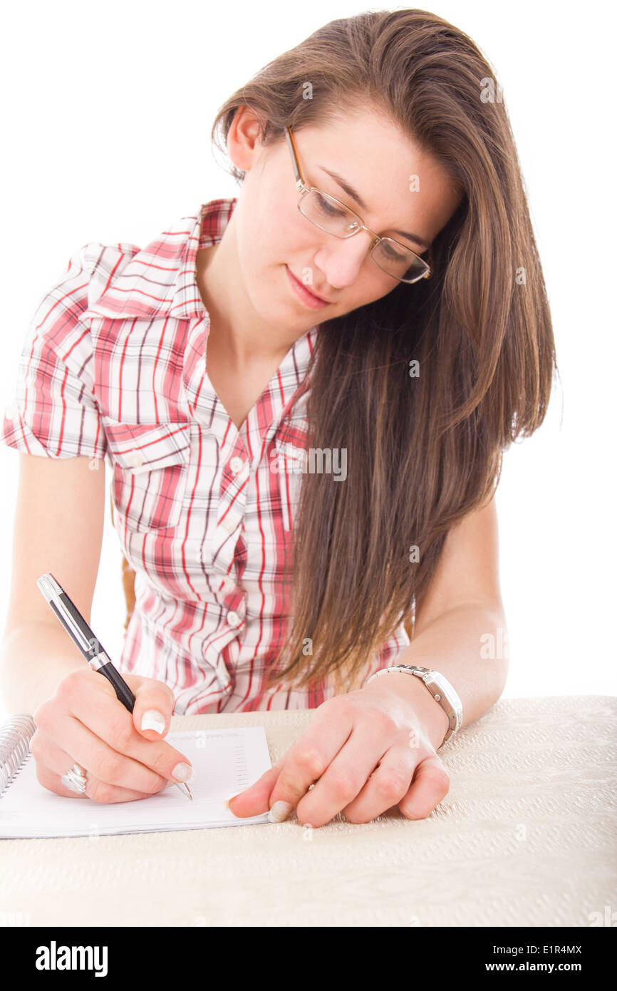 student girl wearing glasses with pen and notebook writing at desk ...