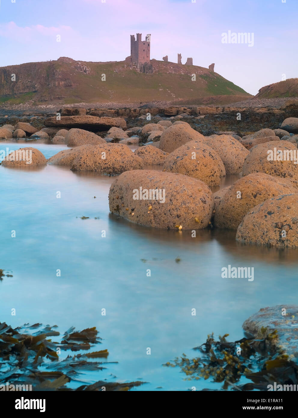 Dunstanburgh Castle at low tide Stock Photo - Alamy
