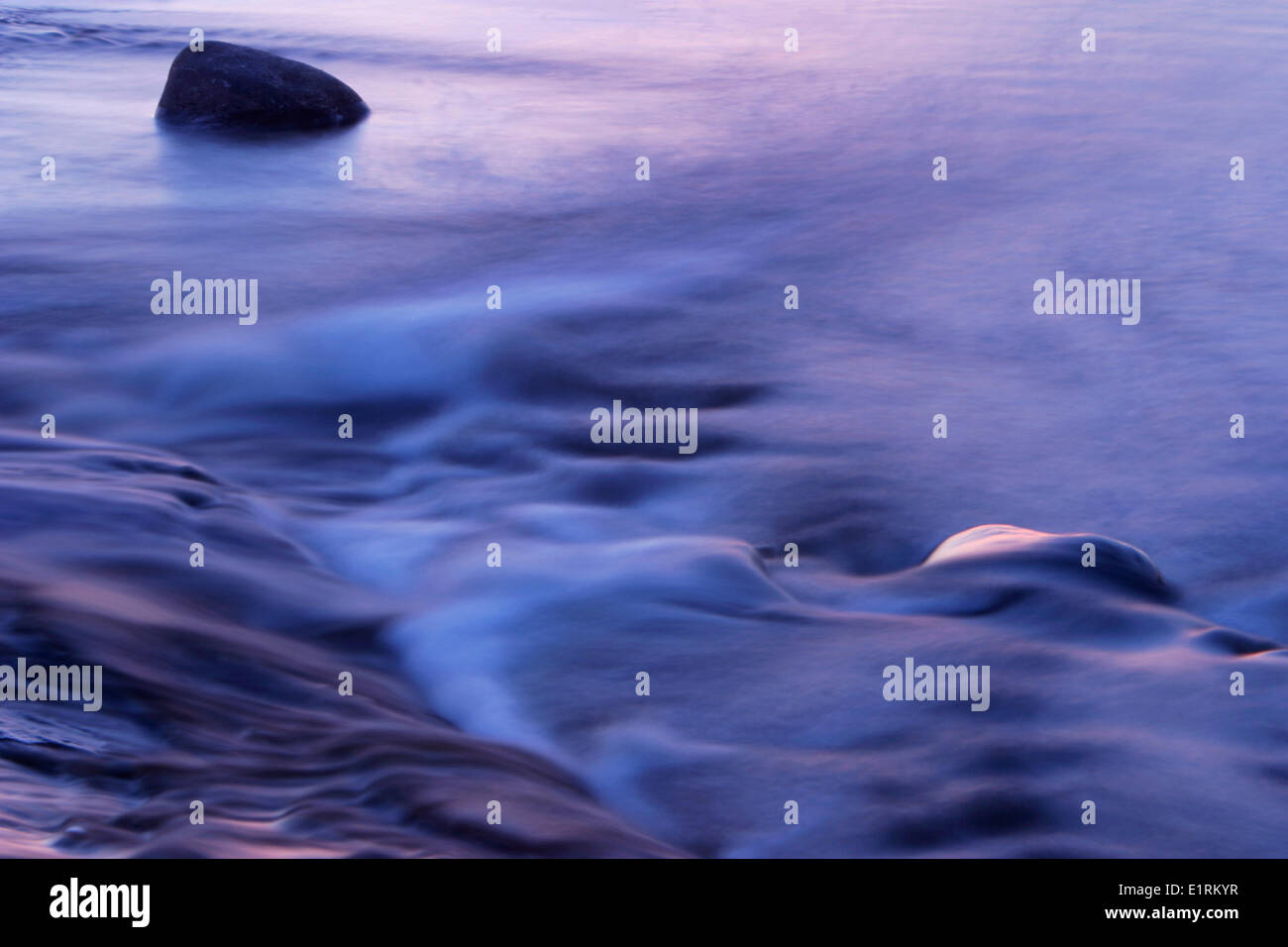 Rock in purple water Stock Photo - Alamy