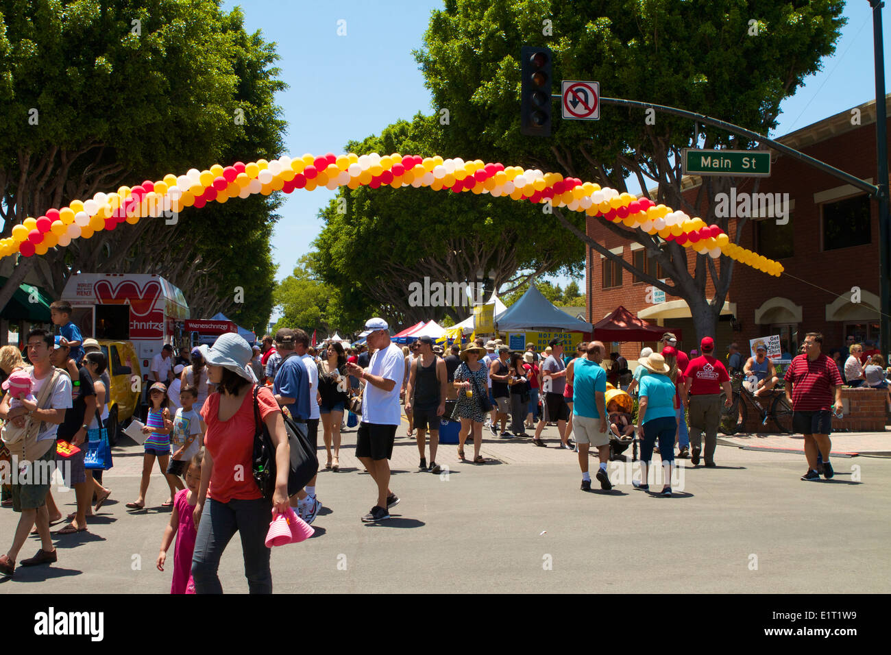 People walking in the sunshine at a street fair and chili cook-off in ...