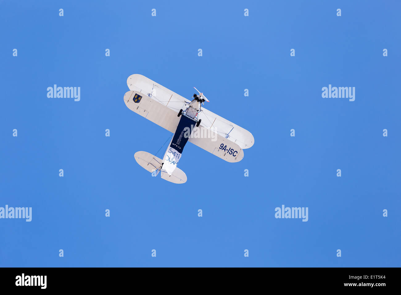 A bi-plane aircraft flies over riva trailing a banner for Sveti Dujam ...