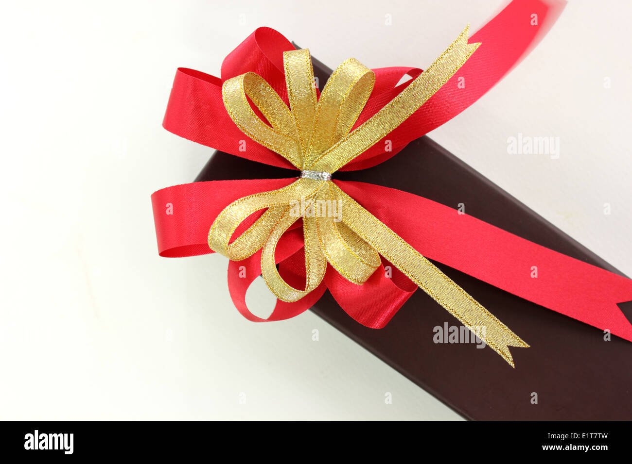 A gold and red ribbon bow with giftbox on white background Stock Photo ...