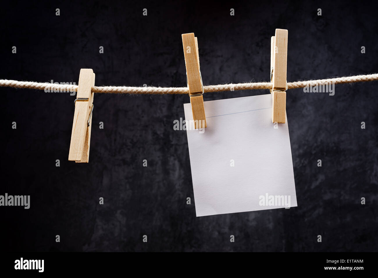 Blank note paper hanging on rope with clothes pins, copy space for your ...