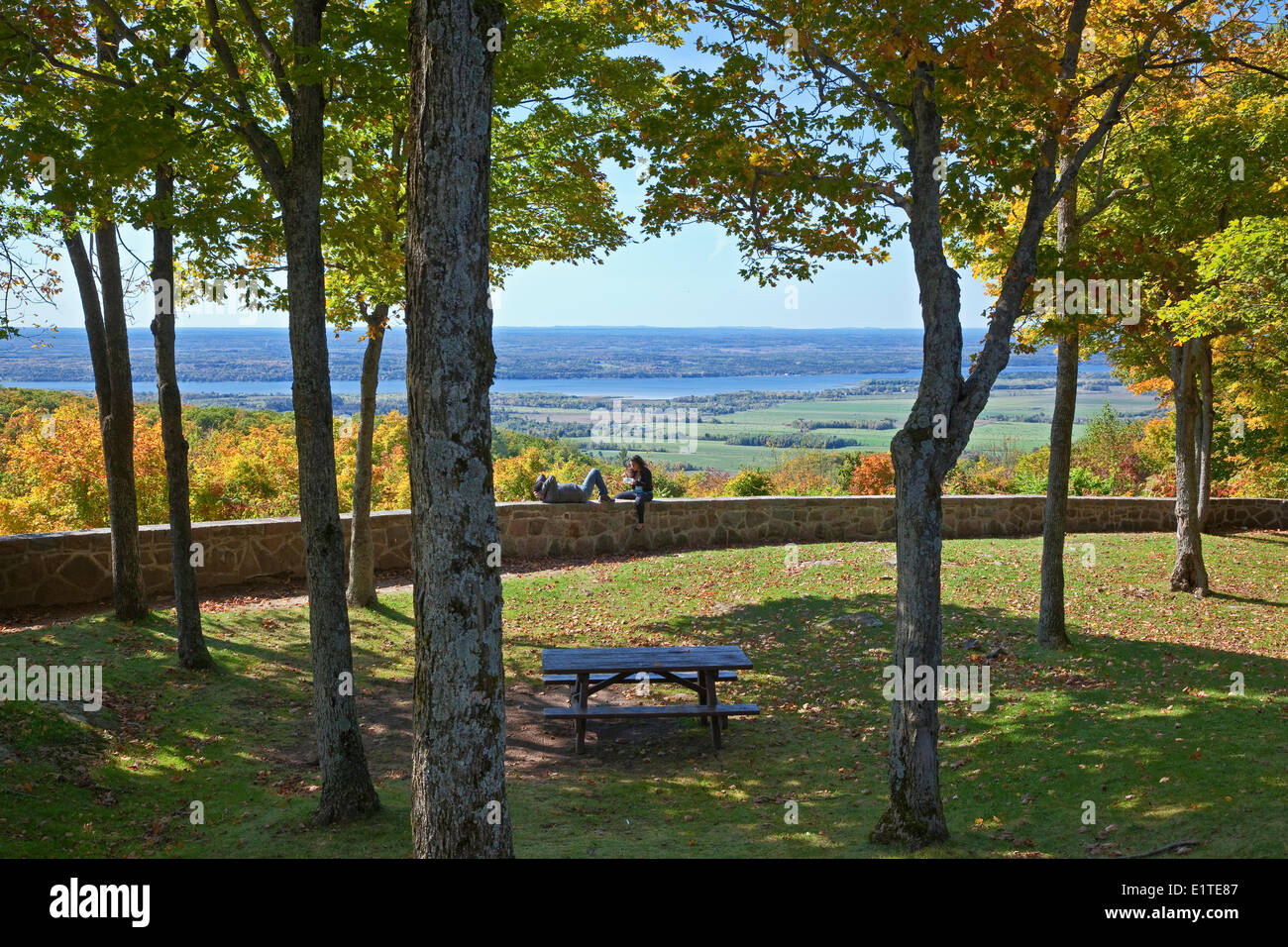 Couple sitting on stone masonry guardrail overlooking the ottawa river ...