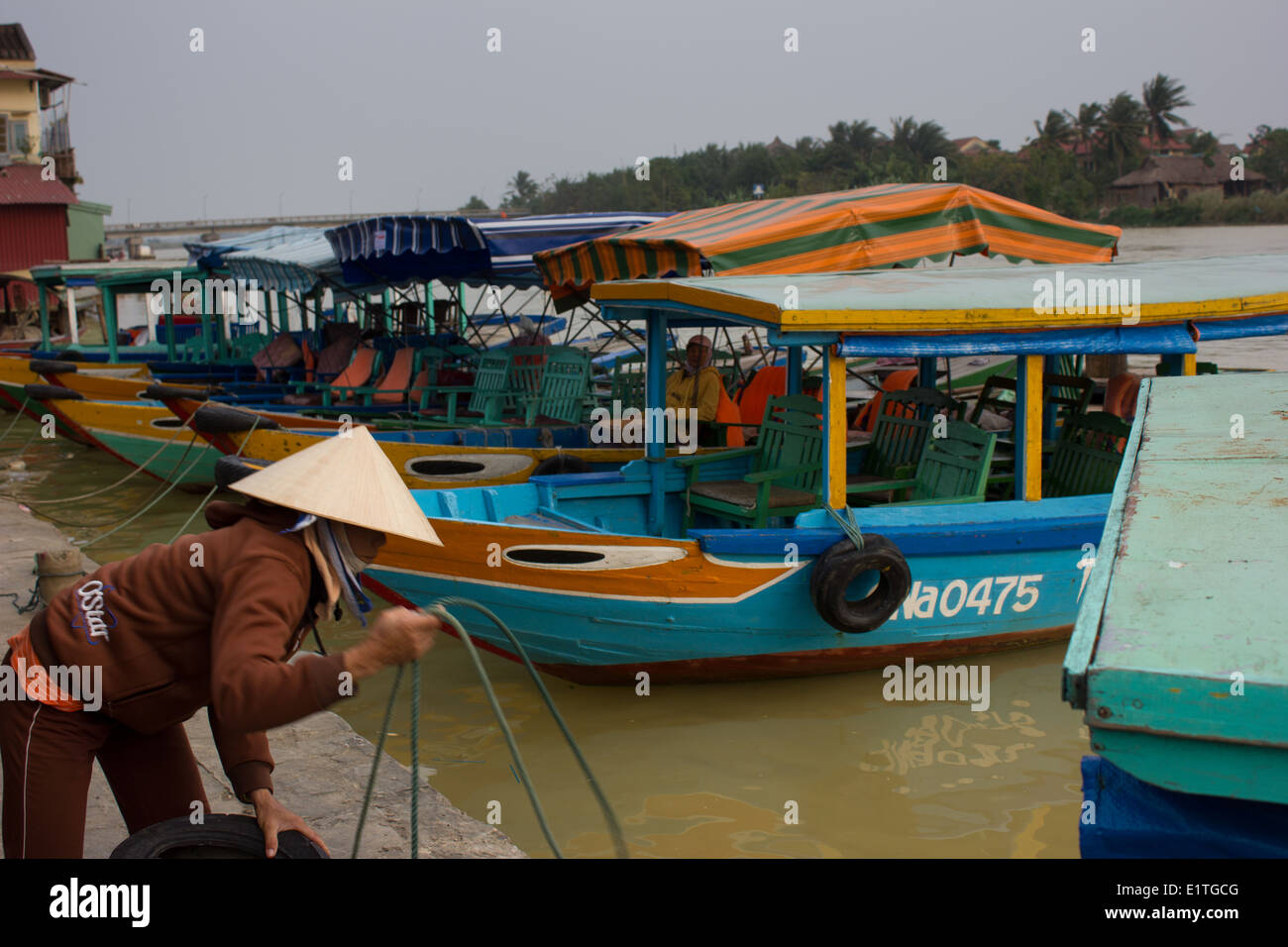 Riverside scene in Hoi An, Vietnam with tourist boats and food sellers ...