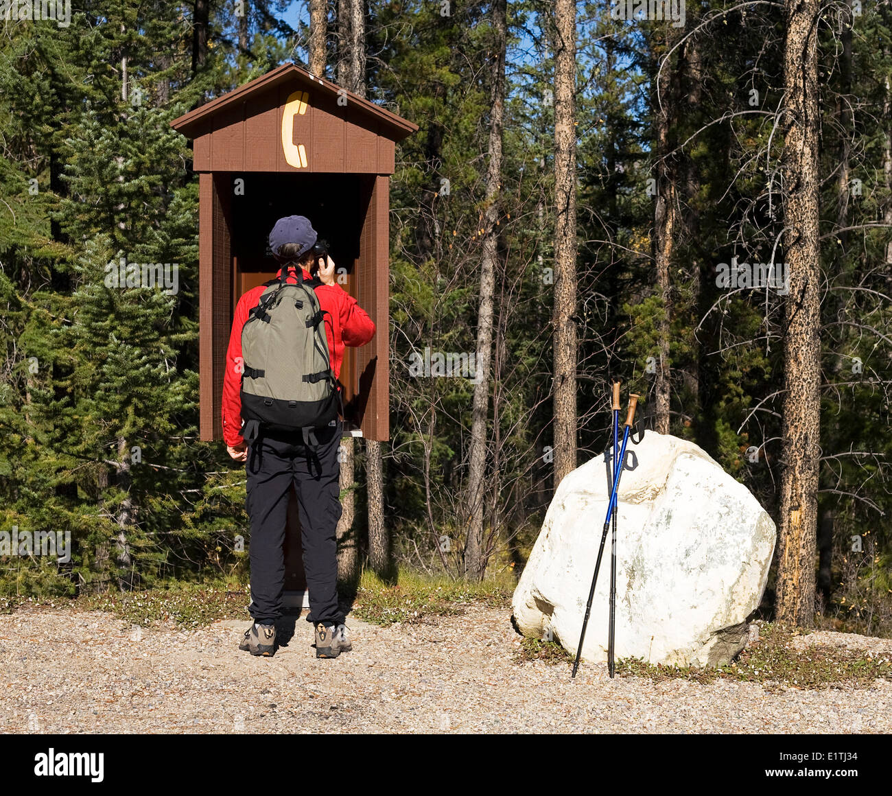 Hiker calling on outdoor pay phone, Jasper National Park, Alberta ...