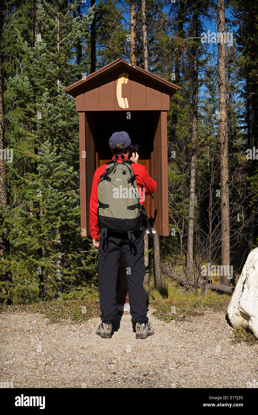 Hiker calling on outdoor pay phone, Jasper National Park, Alberta ...