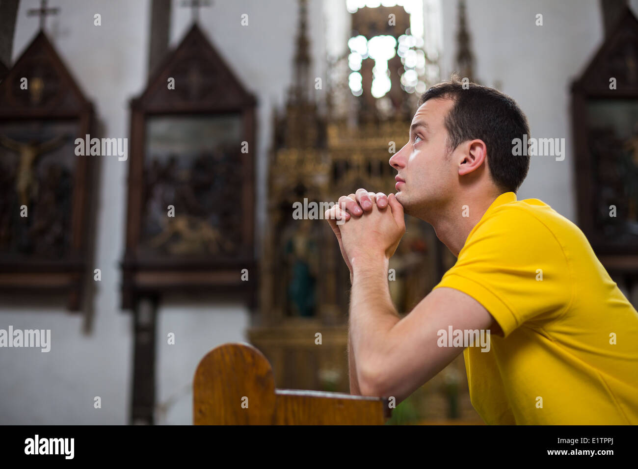 Handsome young man praying in a church Stock Photo - Alamy