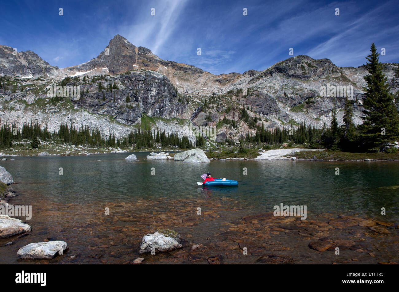 Hiker rafts Gwillim Lakes below Lucifer Peak, Selkirk Mountains ...