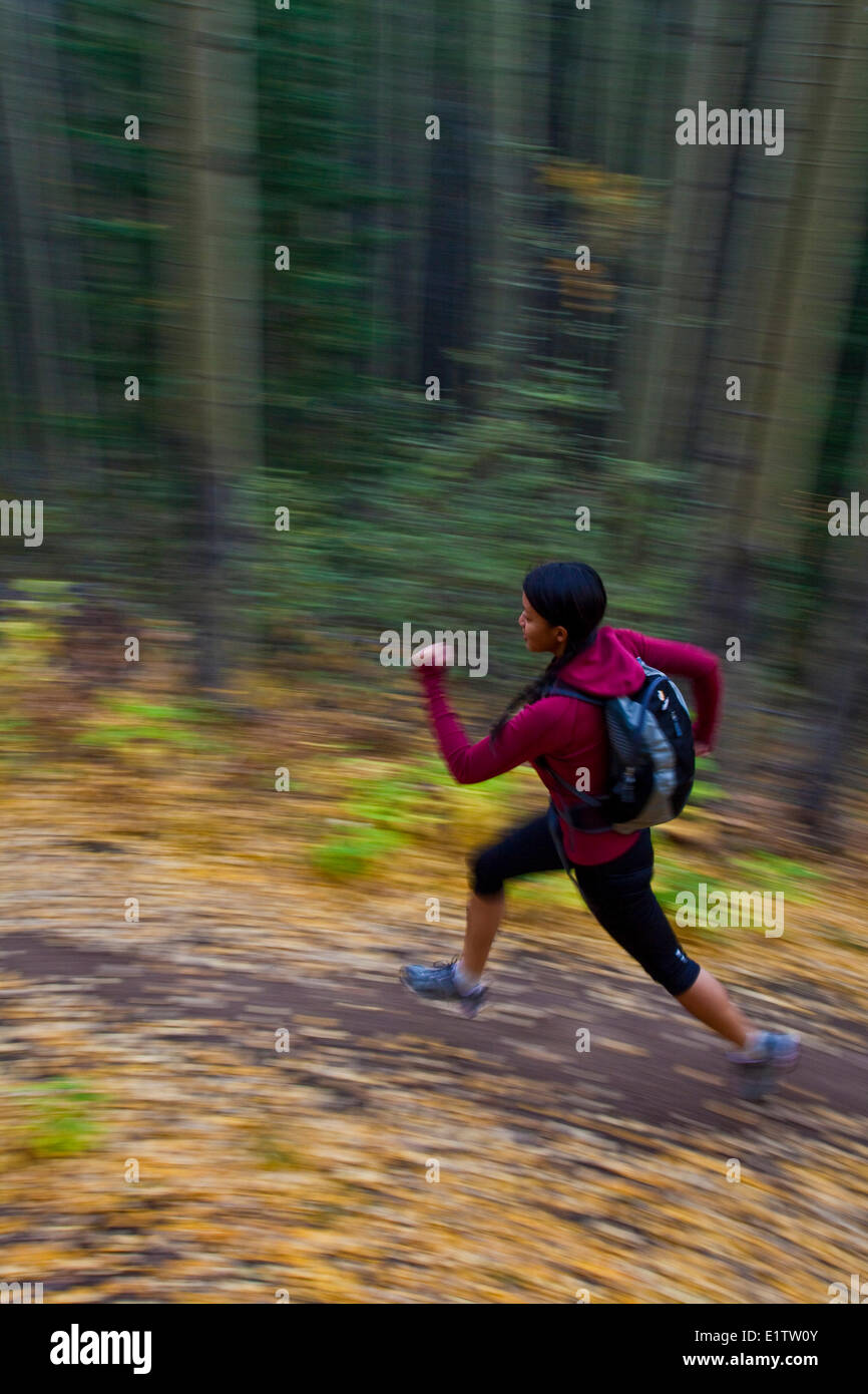 A young, fit woman trail running the Highline trail in Canmore, AB ...
