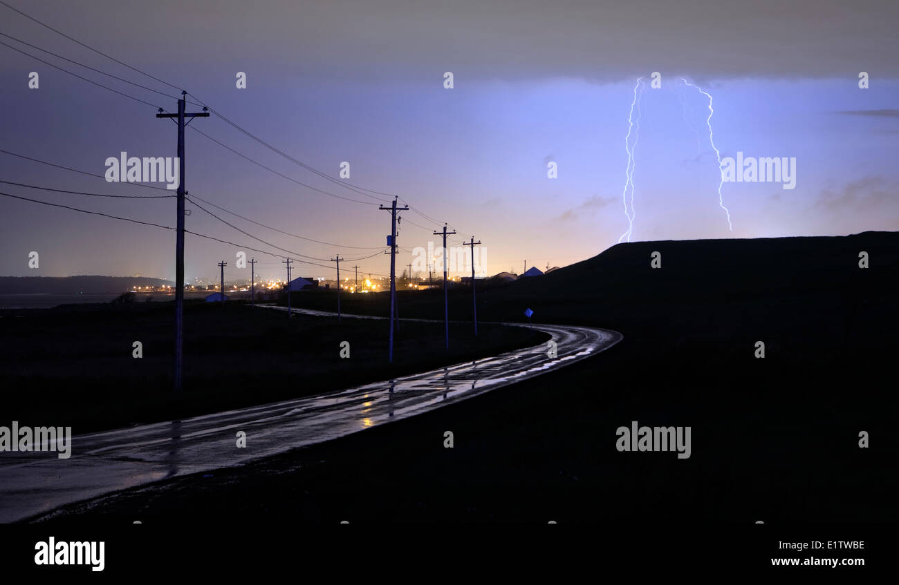 Wet road and utility poles illuminated by lightning strike in Eastern ...