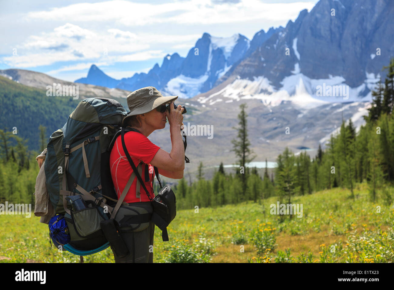 A backpacker taking a photograph near Wolverine Pass with the Rock Wall ...