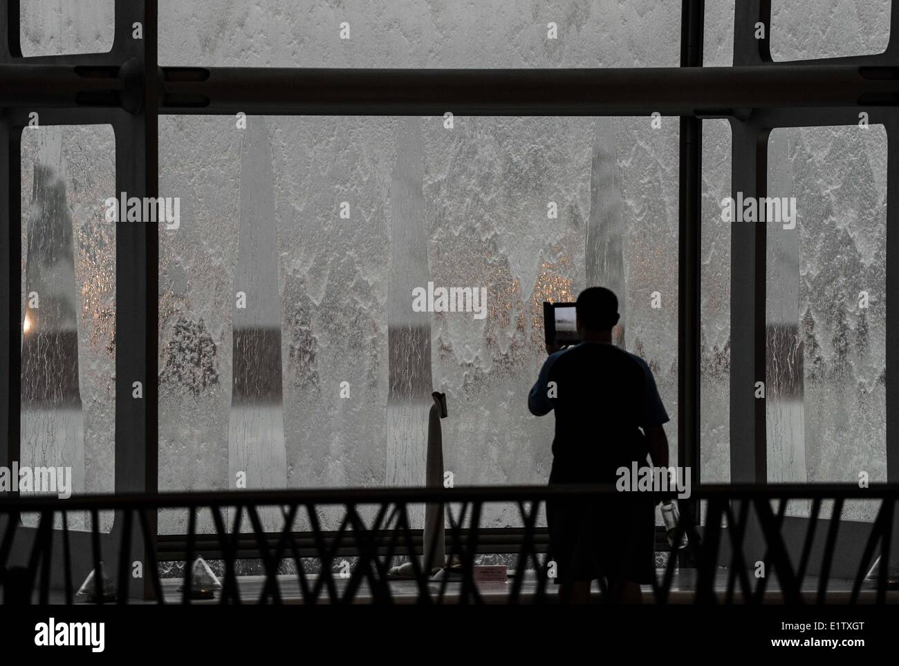 Beijing, China. 10th June, 2014. A tourist takes photos of a downpour ...