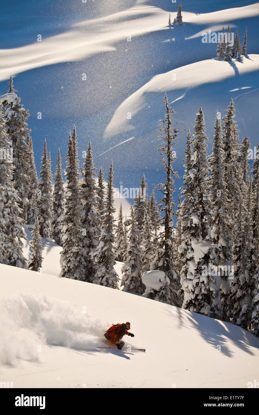 A man skiing deep powder while backcountry skiing at Sol Mountain ...
