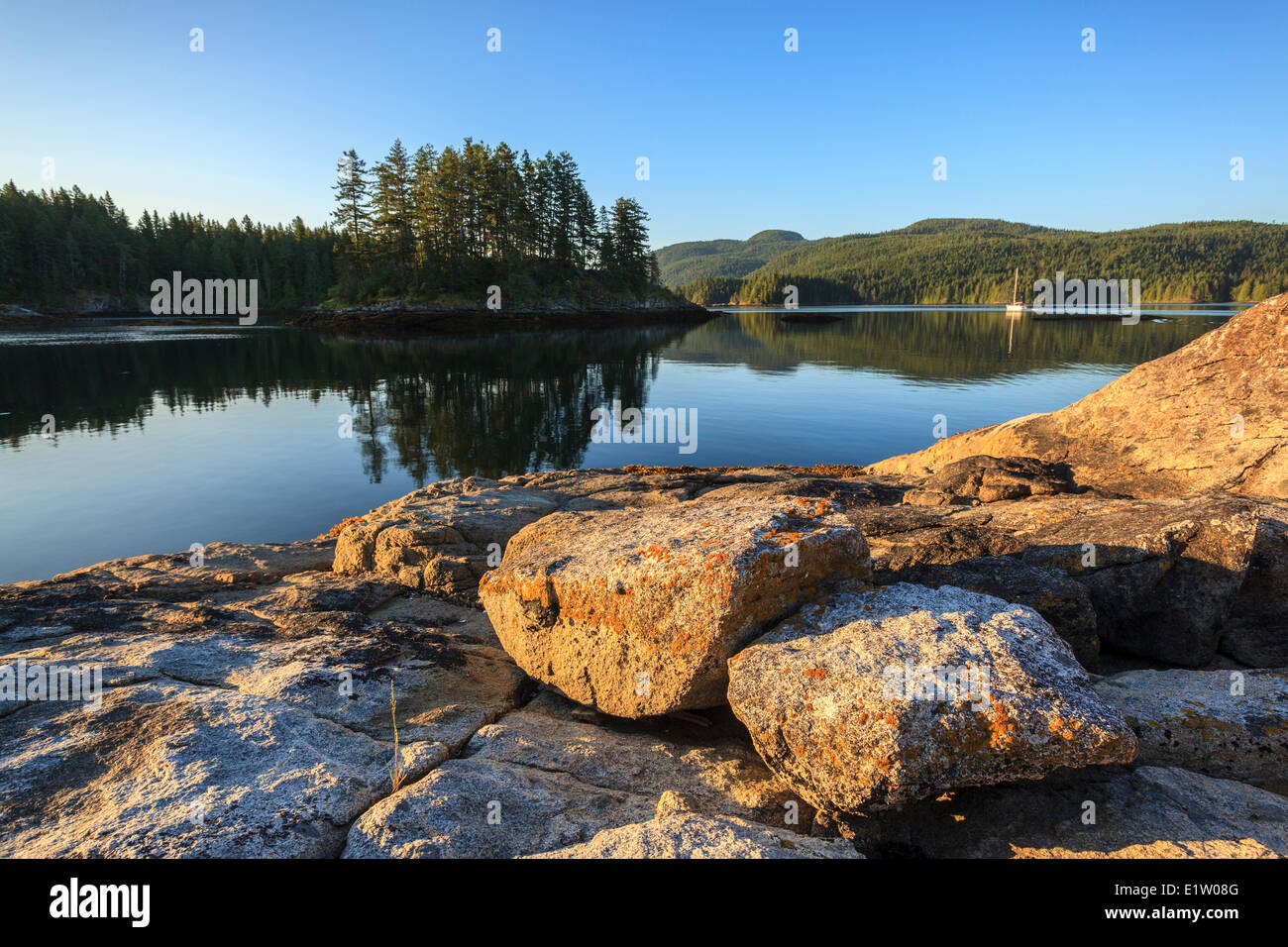 Sunrise warms the rocks on Octupus Island Provincial Marine Park as a ...