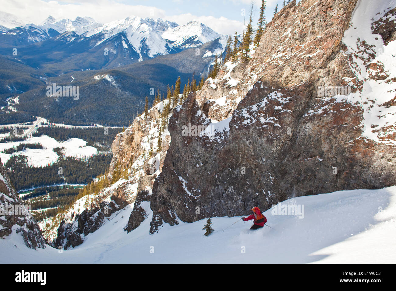 A male backcountry skier rips down a steep coulior close to downtown ...
