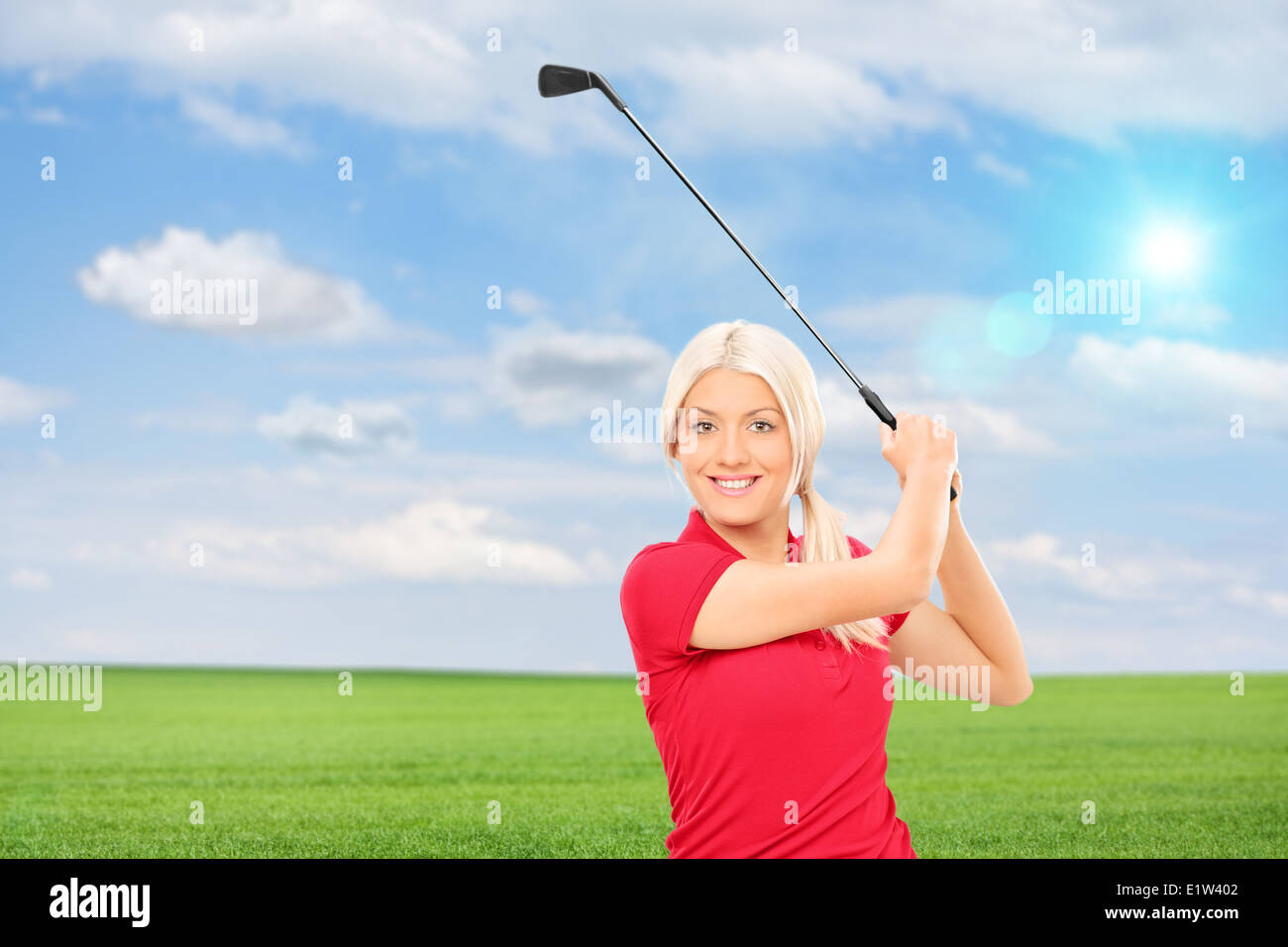 Woman playing golf in a field on a sunny day Stock Photo - Alamy